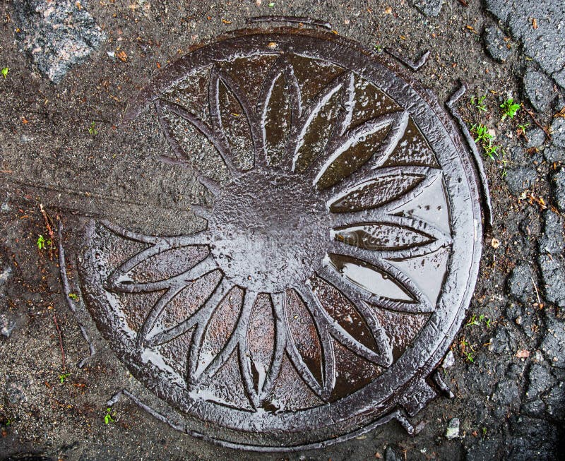 Manhole with Wet Metal Cover in the Cracked Asphalt Surface Stock Photo ...