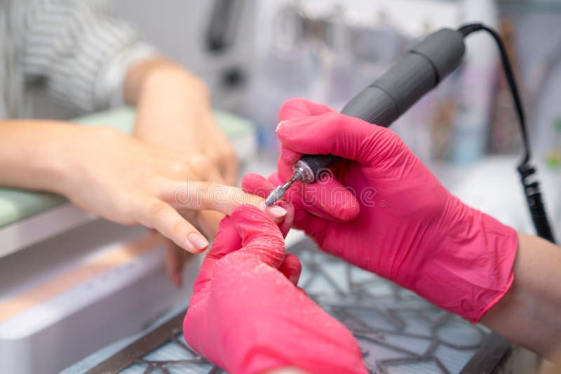 Manicure Master Uses a Drill Machine for a Manicure at a Beauty Salon ...