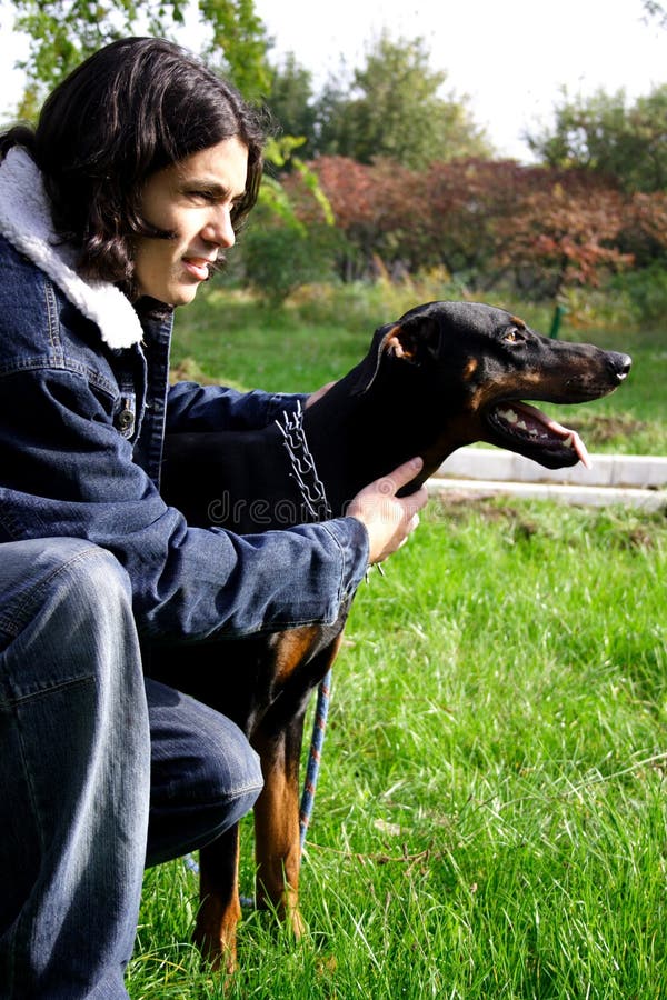 Mann mit Hund stockbild. Bild von hund, gras, grün, dobermann - 1451093