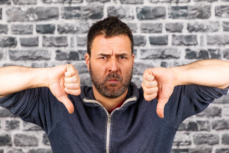 Mann Zeigt Daumen Runter Vor Einer Steinwand Stockbild - Bild von unten ...