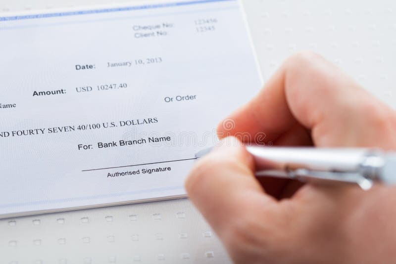 Mano Con La Pluma Sobre Talonario De Cheques Imagen de archivo - Imagen ...