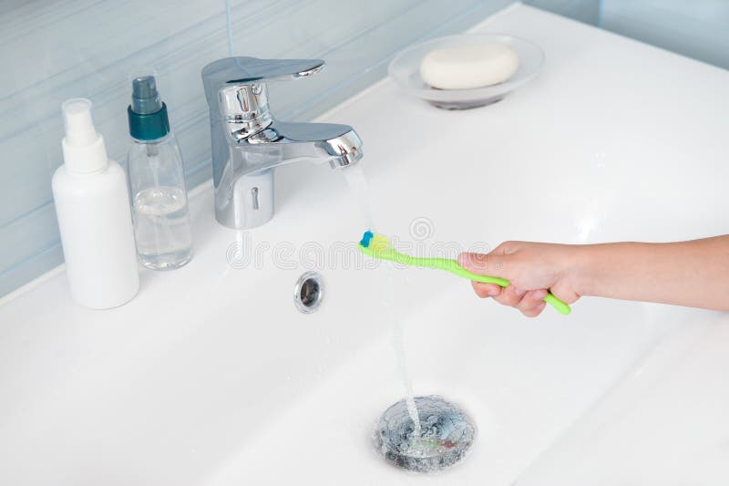 Cepillo De Dientes Que Se Lava De La Mano Debajo De La Agua Corriente ... Cepillo De Dientes Que Se Lava De La Mano Debajo De La Agua Corriente ...