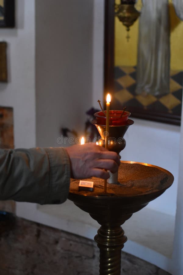 Mano Sostiene Una Vela En El Templo. Rito Ortodoxo Religioso. Encender ... Mano Sostiene Una Vela En El Templo. Rito Ortodoxo Religioso. Encender ...