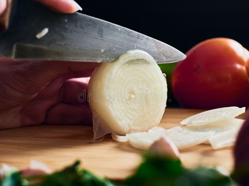 Manos Cortando Una Cebolla En Una Tabla De Madera Foto de archivo ...