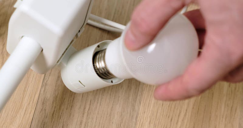Mans Hands Replacing a Light Bulb in Lamp. Close-Up. Stock Image ...