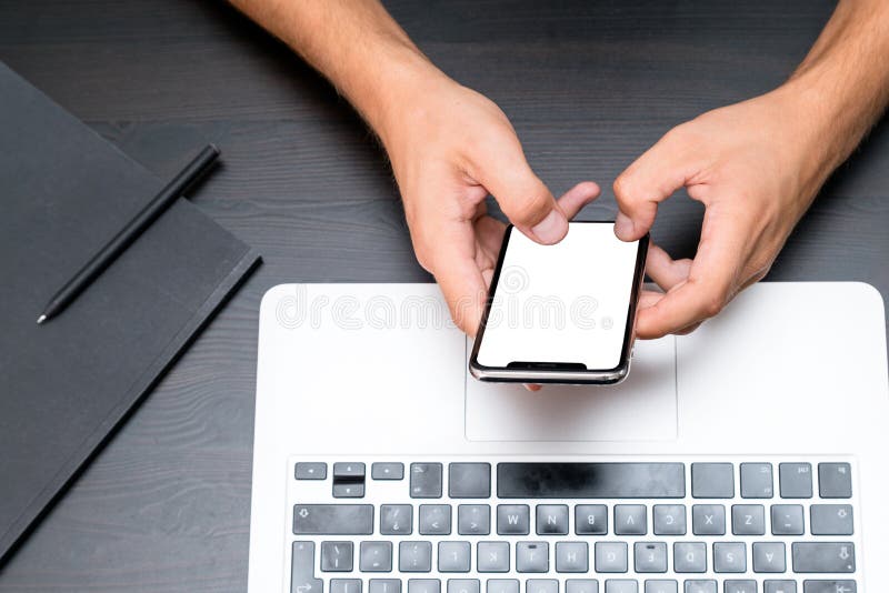 Mans Hands Typing on Smart Phone while Working on Laptop Compute Stock ...