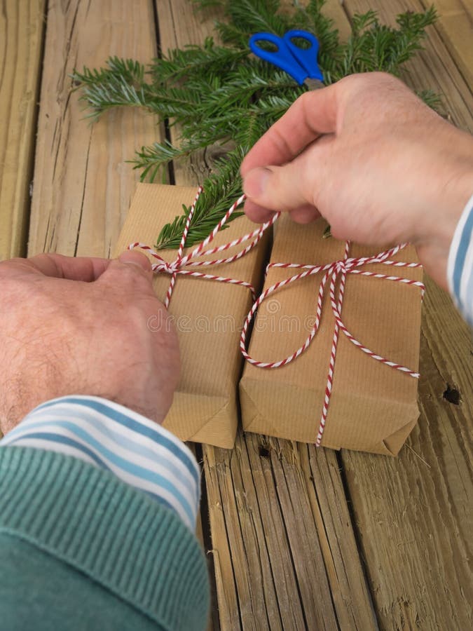 Mans hands wrapping gifts stock image. Image of tied - 47749355