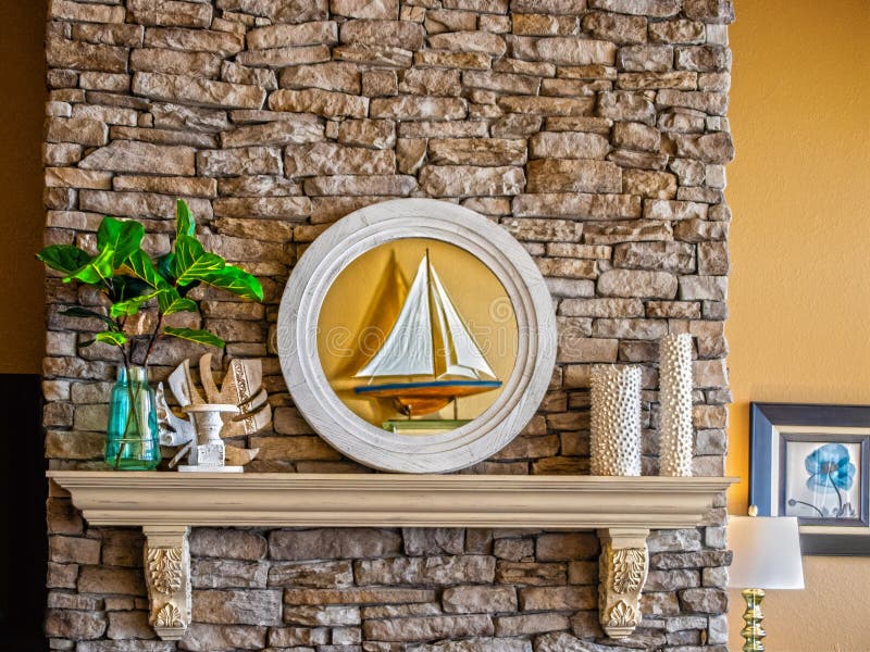 Mantlepiece on Rock Fireplace Decorated with Candles, Fig Leaf in Vase ...