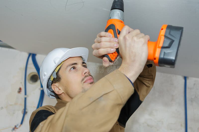 Man drilling ceiling rose stock image. Image of heavy - 122437125