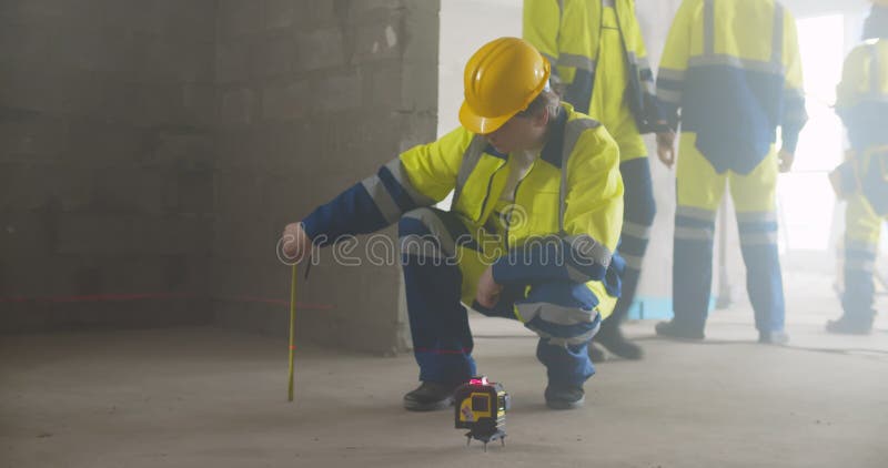 Manual Worker Using Laser Level Machine and Measuring Tape in ...