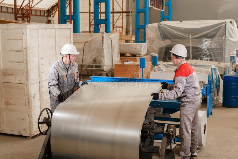 Manufacture Workshop. Workers Adjusts the Machine in the Warehouse. the ...