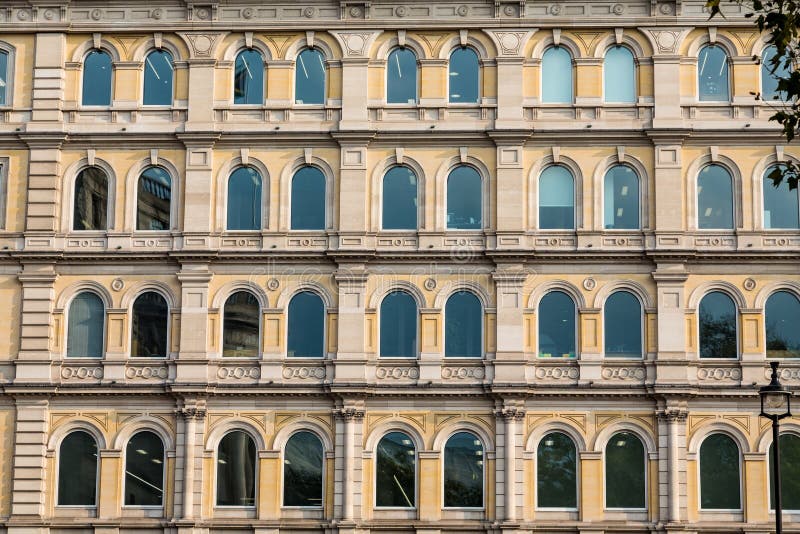 Many Arched Windows on a Red Brick Building Facade, One Window Open ...
