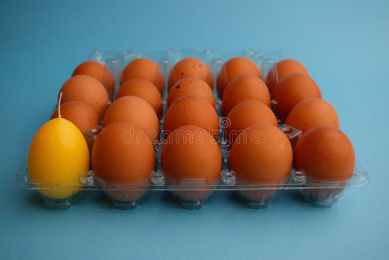 Many Brown Eggs and One Yellow Egg-shaped Candle in a Special Plastic ...