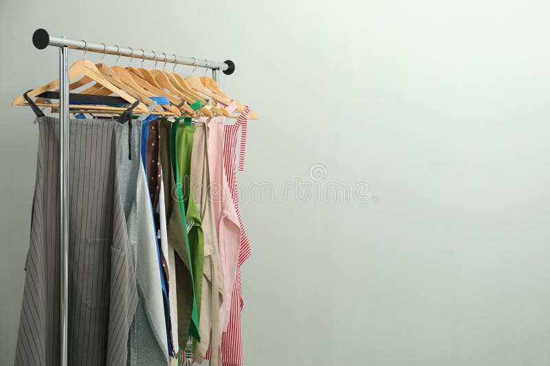 Many Chef S Aprons on Clothing Rack Near Light Grey Wall, Space for ...