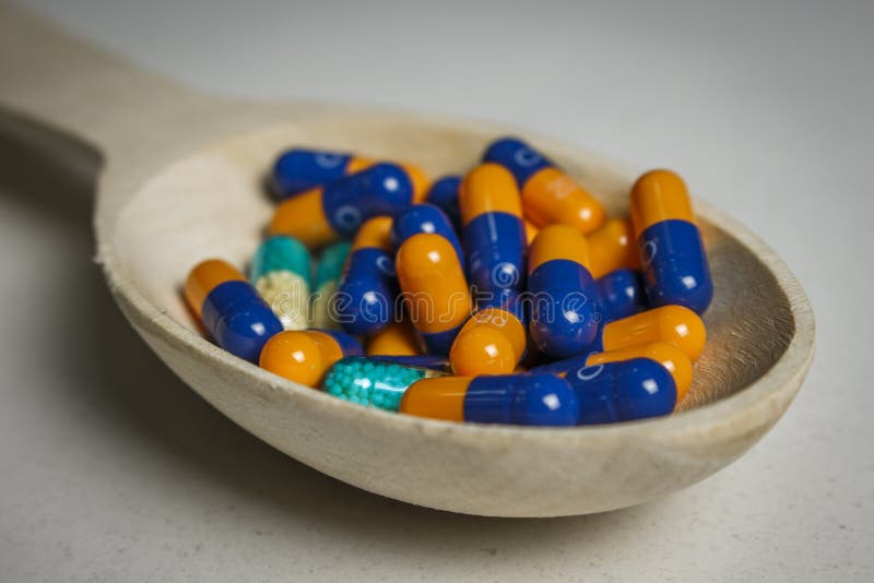 Many Colored Capsules in a Spoon on a White Table Stock Photo - Image ...