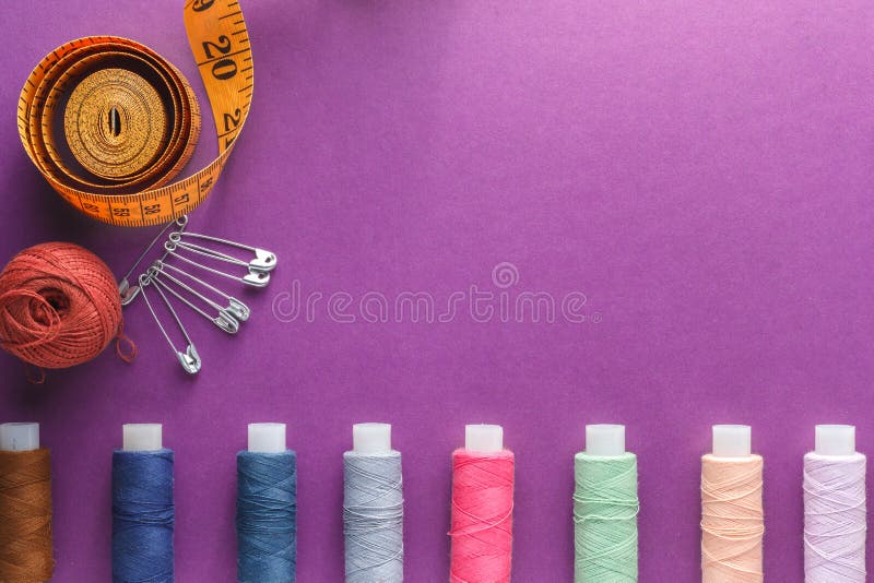 Many Different Colorful Sewing Threads and a Measuring Tape on a Purple ...