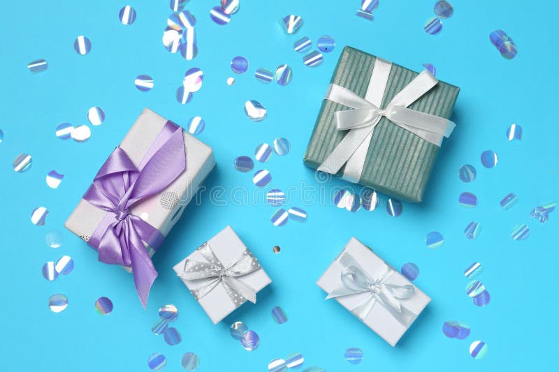 Many Different Gift Boxes and Shiny Confetti on Light Blue Background ...