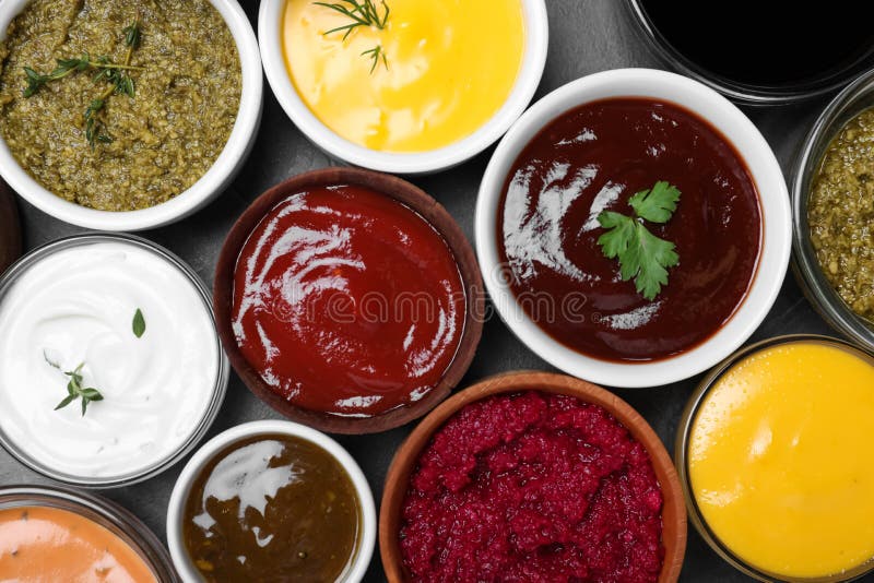 Many Different Sauces and Herbs on Black Table, Flat Lay Stock Photo ...