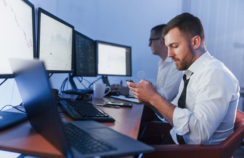 Many Displays on the Table. Two Stock Traders Working in the Office ...
