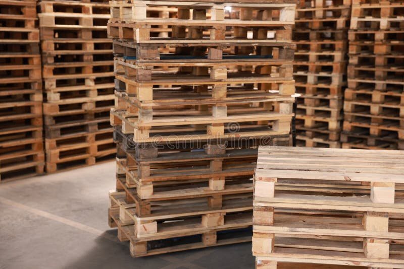Many Empty Wooden Pallets Stacked in Warehouse Stock Photo - Image of ...