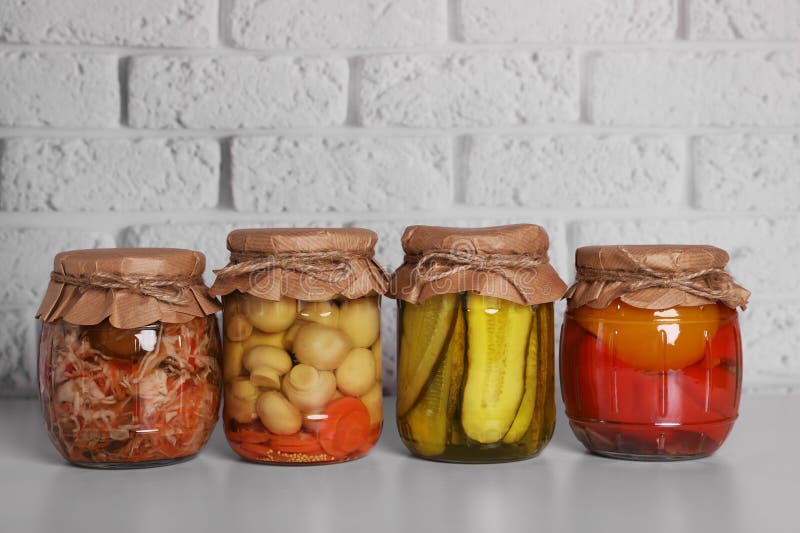 Many Glass Jars with Different Preserved Vegetables and Mushrooms on ...