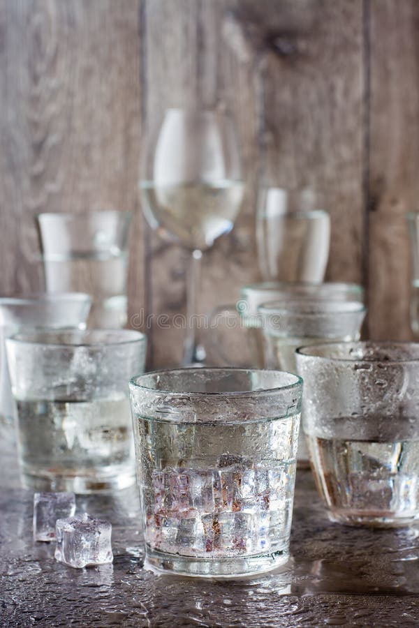 Many Glasses of Water Splashed with Drops and Pieces of Ice Stock Photo ...