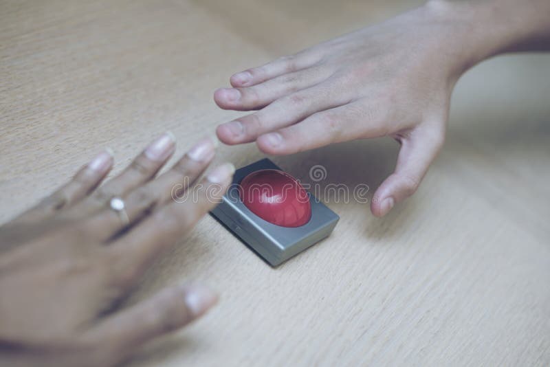 Many Hand Grab for the Red Button on Wood Table. Stock Image - Image of ...
