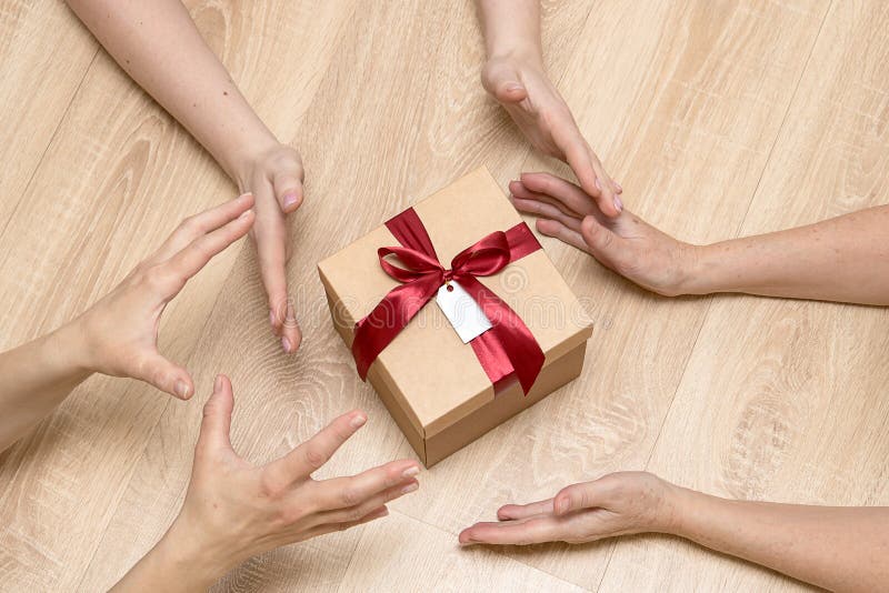 Many Hands Reach for a Gift, a Gift Box Tied with a Bow and an Empty ...