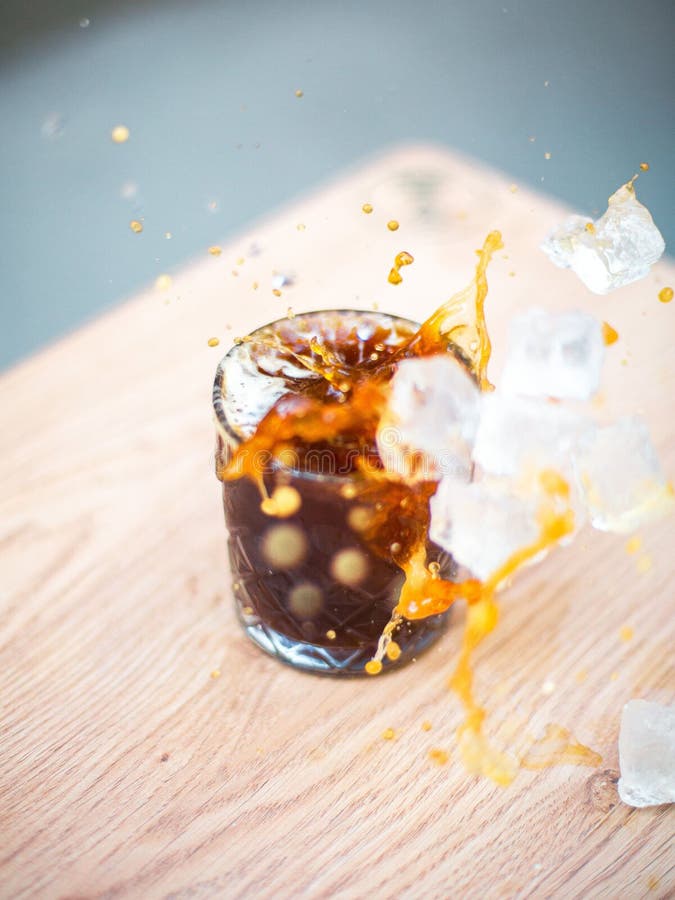Ice Cubes Falling Over a Glass of Coffee on a Table with a Splash Stock ...