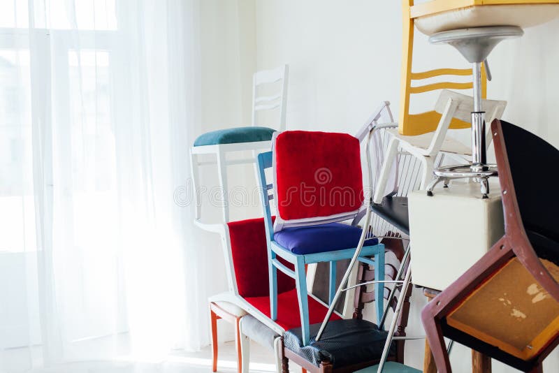 Many Multicolored Chairs In The Mess Of The White Room Stock Photo ...