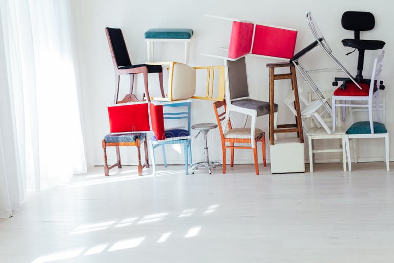 Many Multicolored Chairs in the Mess of the White Room Stock Photo ...