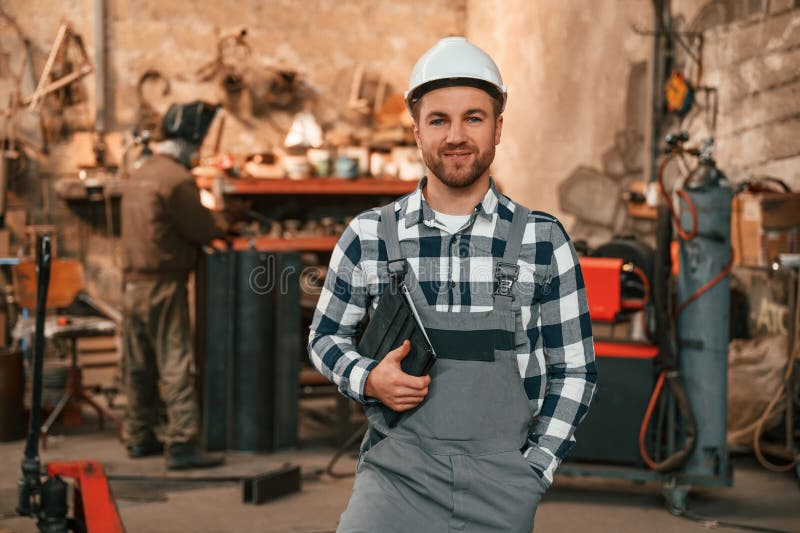 Many Objects Behind. Factory Male Worker in Uniform is Indoors Stock ...
