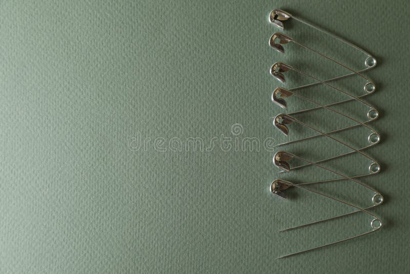 Many Safety Pins on Green Background, Flat Lay. Space for Text Stock ...