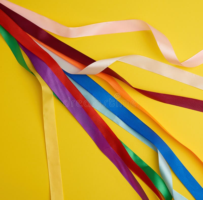 Many Silk Multi-colored Ribbons on a Yellow Background Stock Photo ...