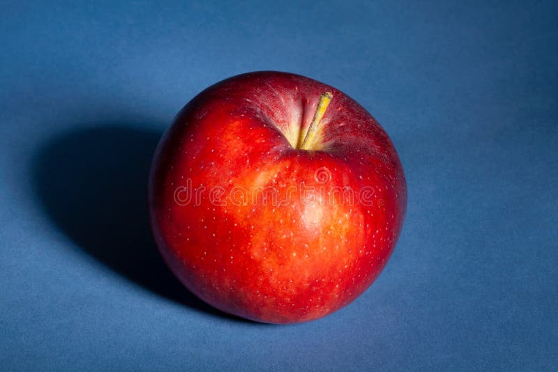 Manzana roja sobre azul foto de archivo. Imagen de fresco - 214340810
