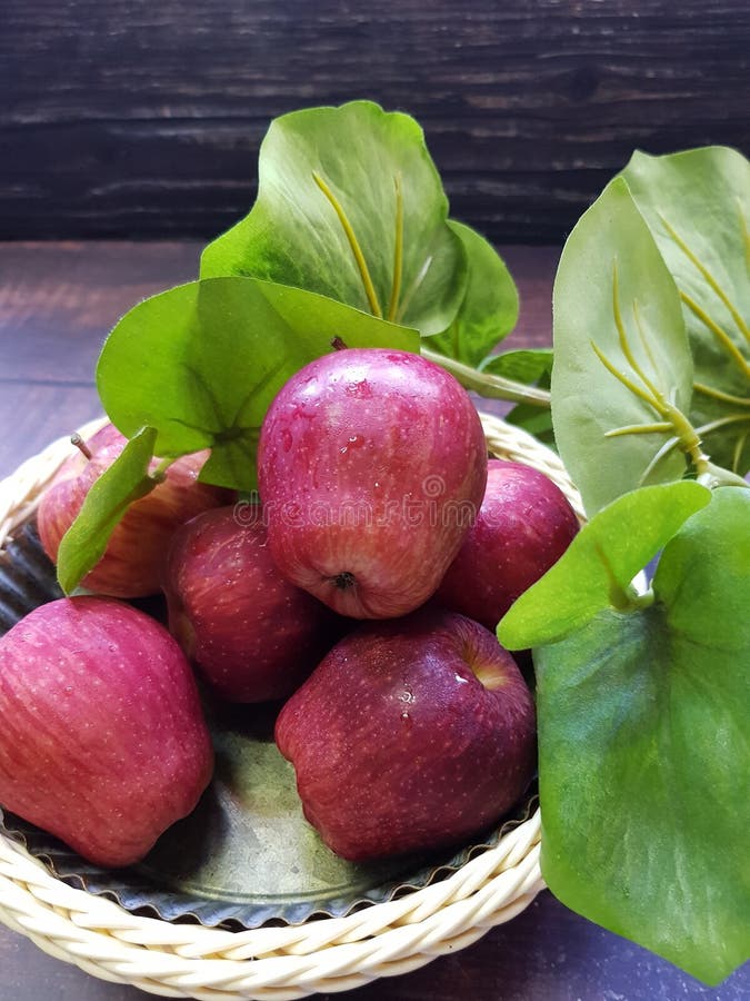 Manzanas Rojas En La Cesta Con Hoja Sobre La Mesa Foto de archivo ...