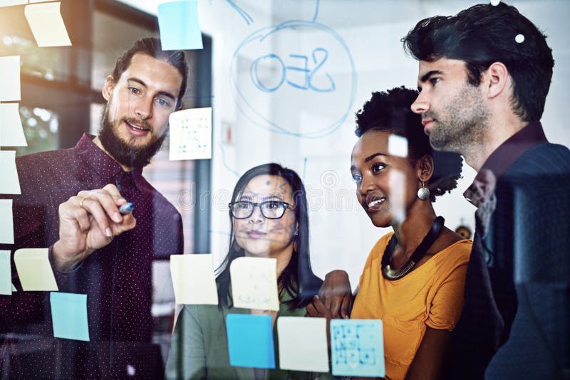 Mapping Out a Strategy. a Group of Businesspeople Working on a Glass ...