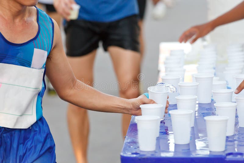 Marathon Racer Catching Cup of Water Stock Photo - Image of passing ...