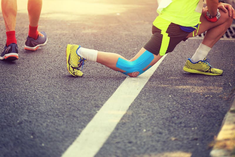 Marathon Runner Stretching Legs Stock Photo - Image of injury, colorful ...