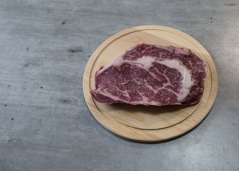 Marble Beef Rib Eye Steak on a Wooden Board before Cooking Stock Image ...