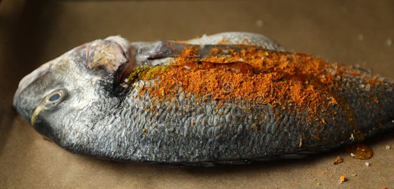 Marinated Fish with Spices on Parchment in Front of the Grill. Dorado ...