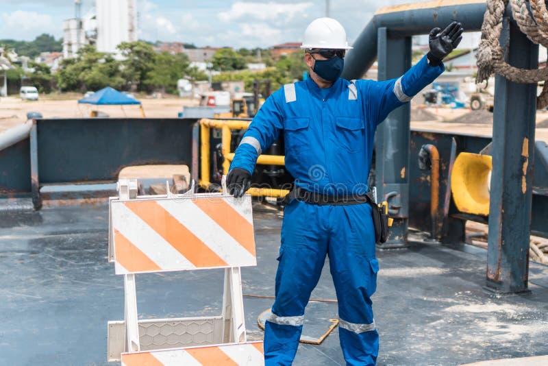 Marine Deck Officer with Protective Mask on Ship Deck Pointing with Arm ...