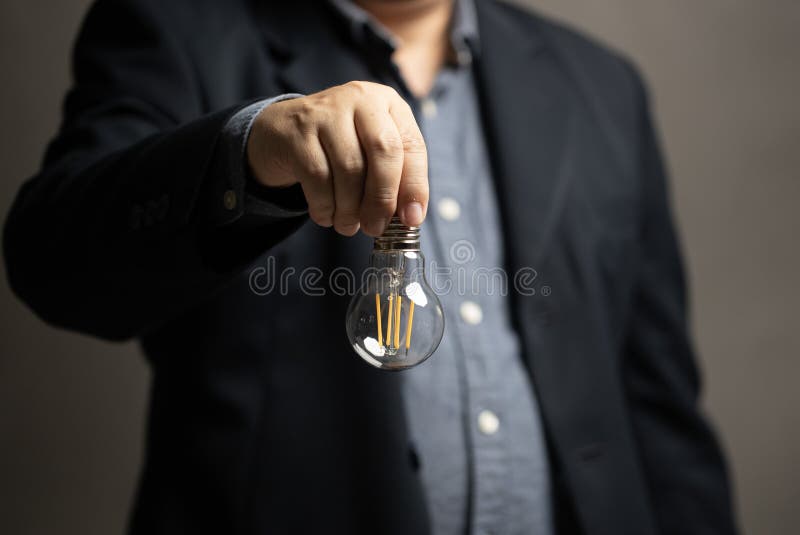 Marketer Holds a Light Bulb Upside Down. Ideas in Decline a Perspective ...