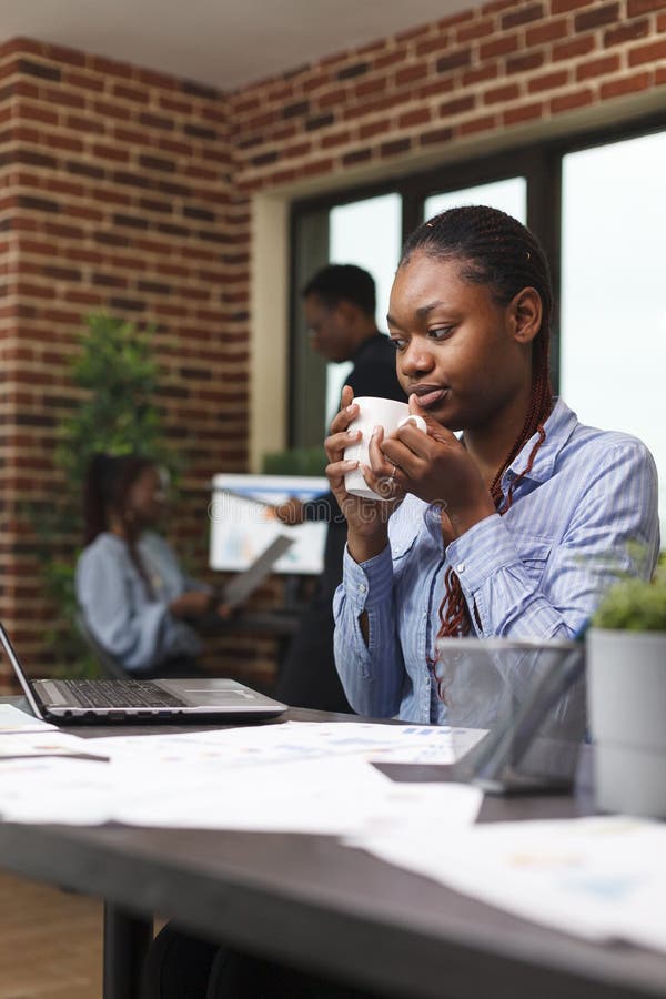 Marketing Agency Office Worker Having a Cup of Coffee while Looking at ...