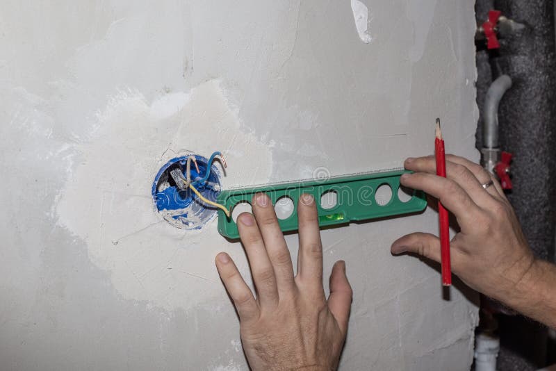 Marking an Additional Socket of an Electrical Outlet on a Cement Wall ...