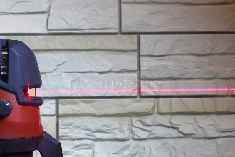 Marking a Wall Using a Laser Level. Red Beam on a Stone Wall. Repair ...