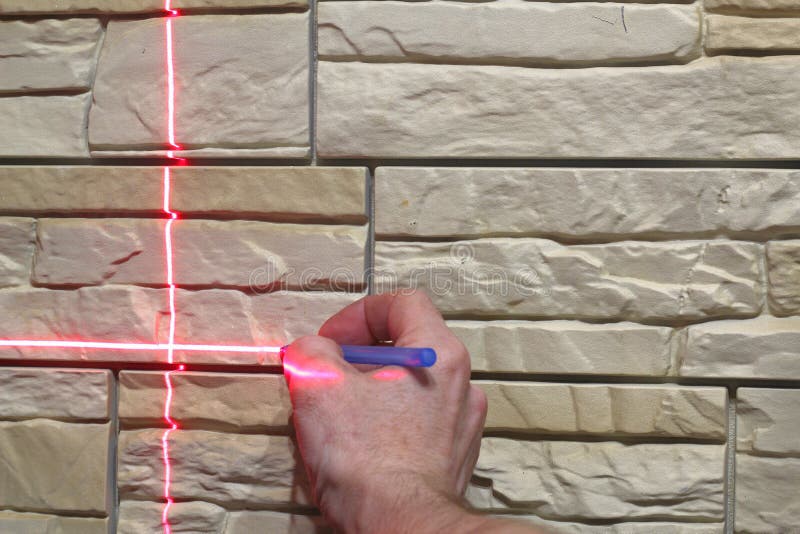 Marking a Wall Using a Laser Level. Red Beam on a Stone Wall. Repair ...