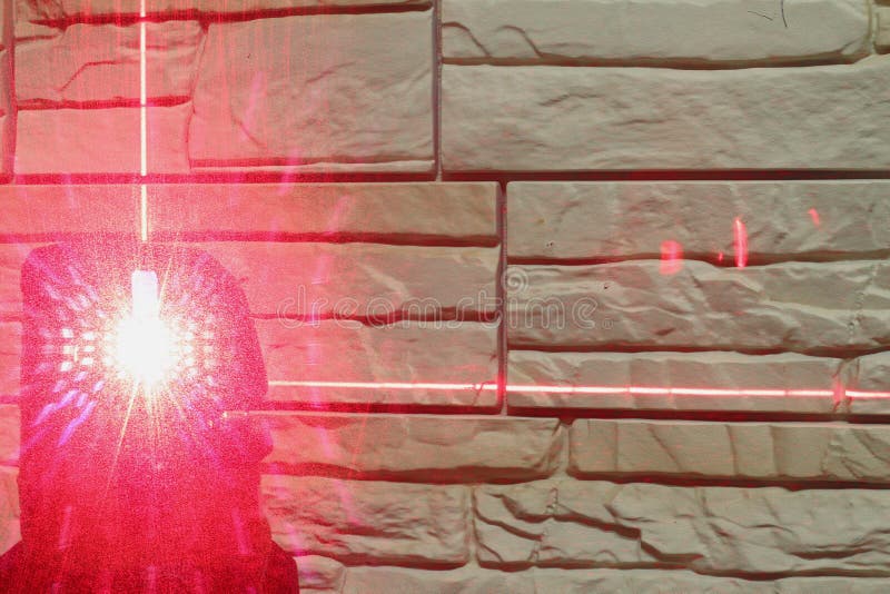 Marking a Wall Using a Laser Level. Red Beam on a Stone Wall. Repair ...