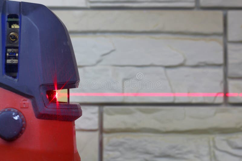 Marking a Wall Using a Laser Level. Red Beam on a Stone Wall. Repair ...