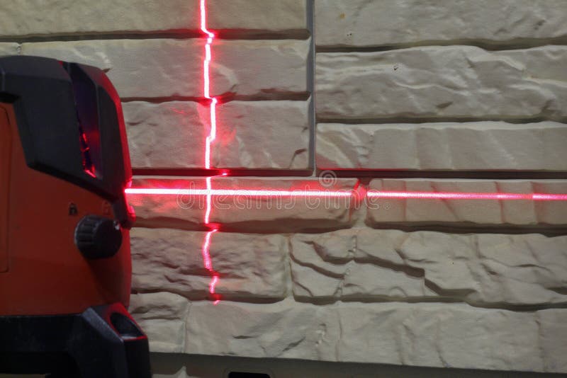Marking a Wall Using a Laser Level. Red Beam on a Stone Wall. Repair ...